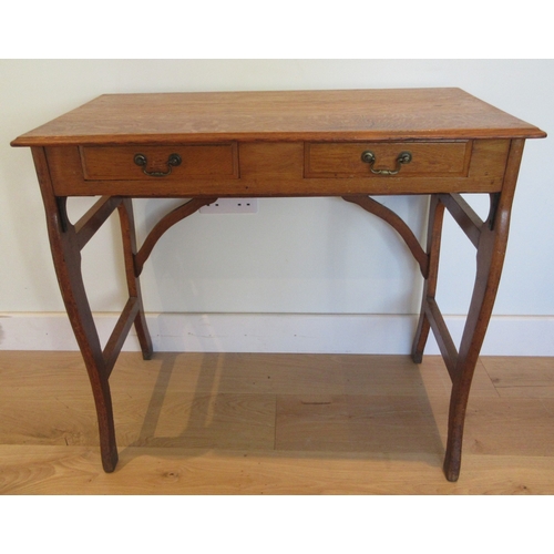 Edwardian golden oak two drawer writing table, curved supports with ...