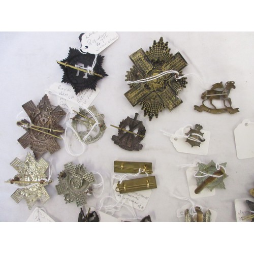 Collection of mostly British military army cap badges, pin badges etc ...