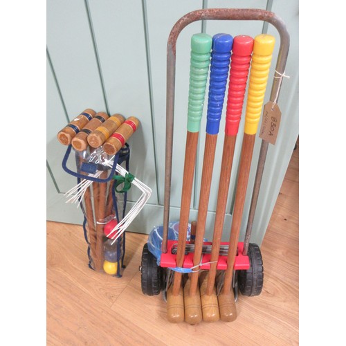 Croquet set with four mallets, hoops and balls, on trolley and a child ...