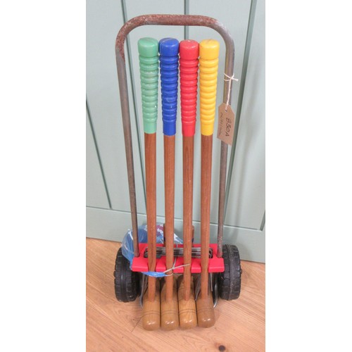 Croquet set with four mallets, hoops and balls, on trolley and a child ...