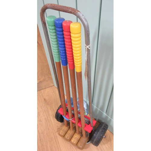 Croquet set with four mallets, hoops and balls, on trolley and a child ...