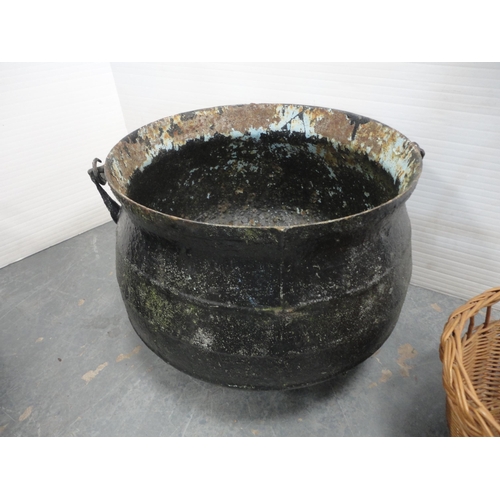 Two painted iron cauldrons with swing handles and a wicker basket. (3)