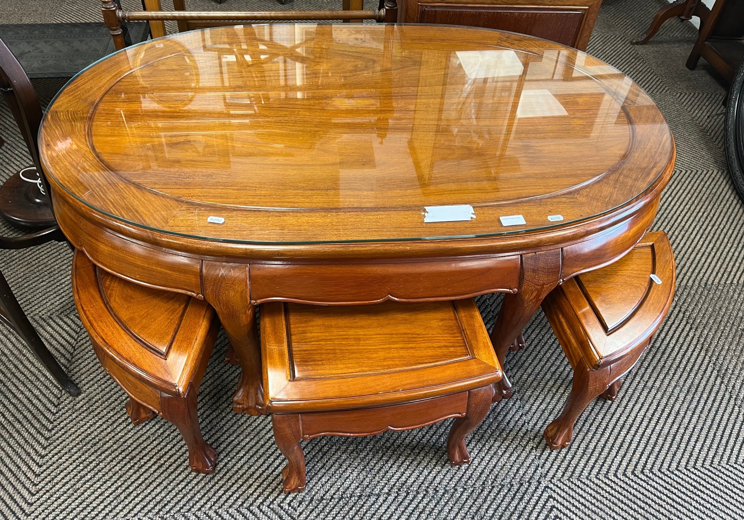 Oriental oval cherry wood coffee table with six occasional tables below