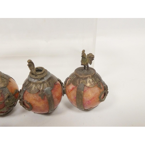 A set of twelve Chinese pink hardstone orbs with white metal finials ...