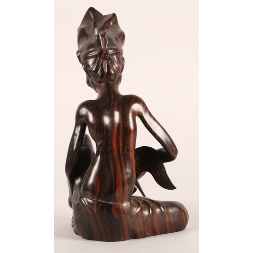 Balinese carved hardwood figure feeding a rooster, 29cm high.
