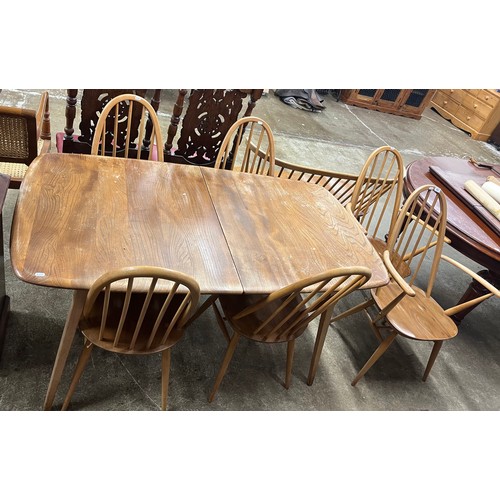 Ercol five leg dining table with six spindle-back chairs.