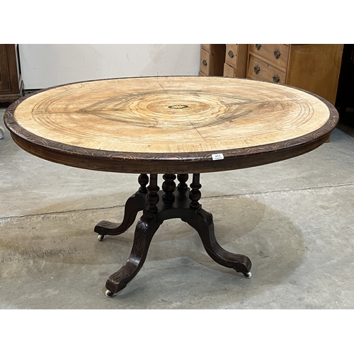 A Victorian walnut and inlaid loo table with oval snap top. 52in long
