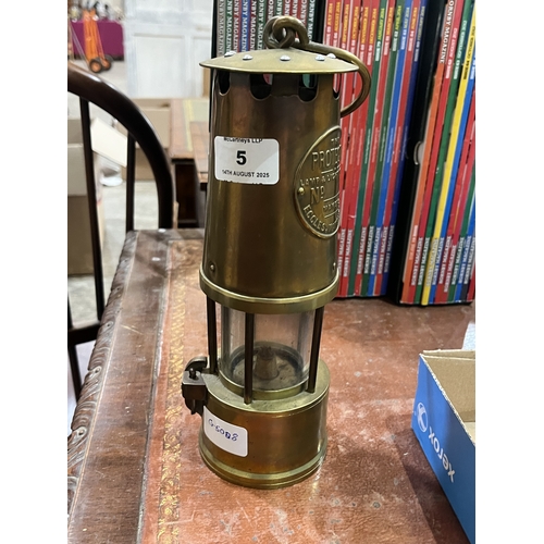 A brass 'The Protector' miner's safety lamp. 10in high