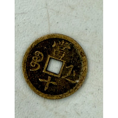 A 19th century Chinese cash coin, with relief characters, 4cm in diameter.