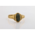 A 18ct yellow gold and hawk's eye ring. set with an oval cabochon stone ...