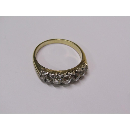 A gold diamond cluster ring with seven graduated central stones with ...