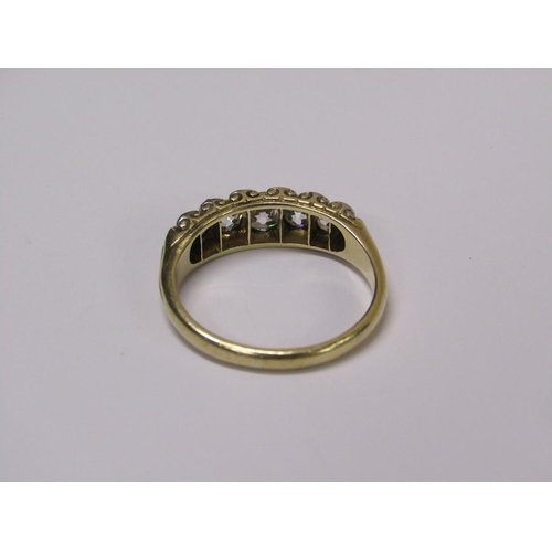 A gold diamond cluster ring with seven graduated central stones with ...