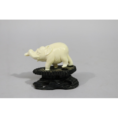 Small carved ivory elephant, wooden stand, small chip to the trunk end ...