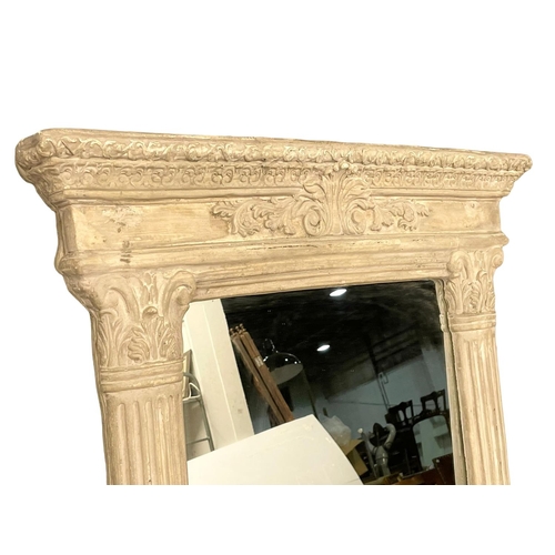 A large ornate heavy gilt framed mirror with Corinthian style pillars ...