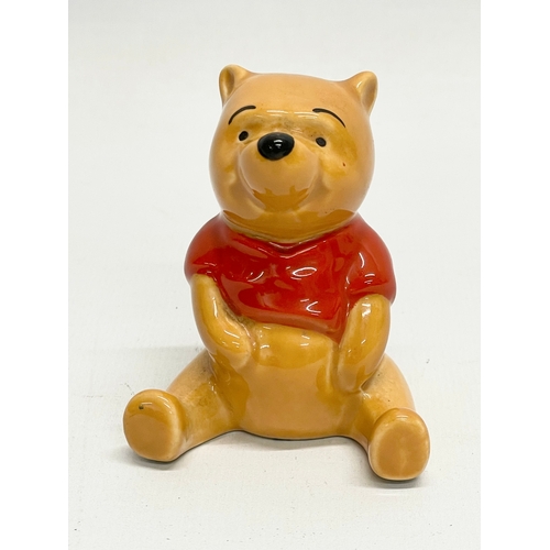 A Beswick pottery Winnie The Pooh and stand. Stand measures 32.5cm
