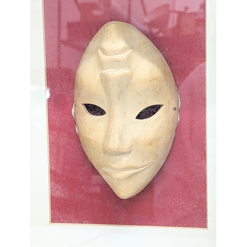 A pair of wooden masks in shadow box frames. 34.5x42cm