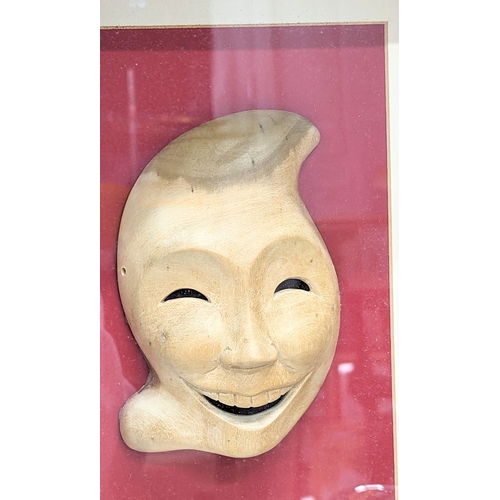 A pair of wooden masks in shadow box frames. 34.5x42cm