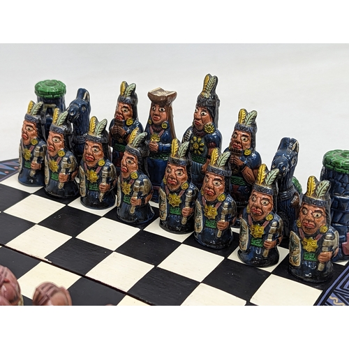 A painted medieval style chess set. Board measures 26cm