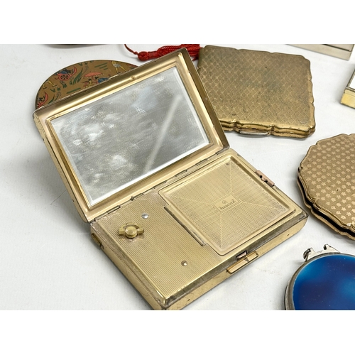A collection of vintage compacts and brooches.