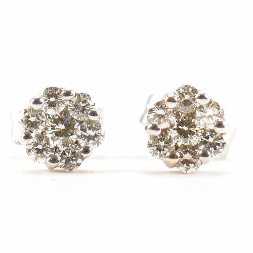 A pair of diamond cluster earrings. The earring being set with seven ...