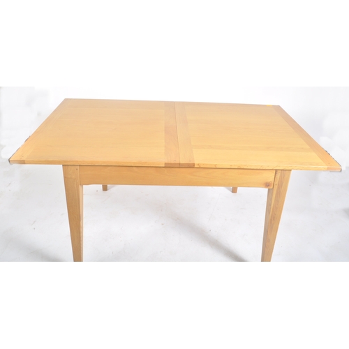 Ercol - A contemporary light oak rectangular extending dining table with chairs. The table having a