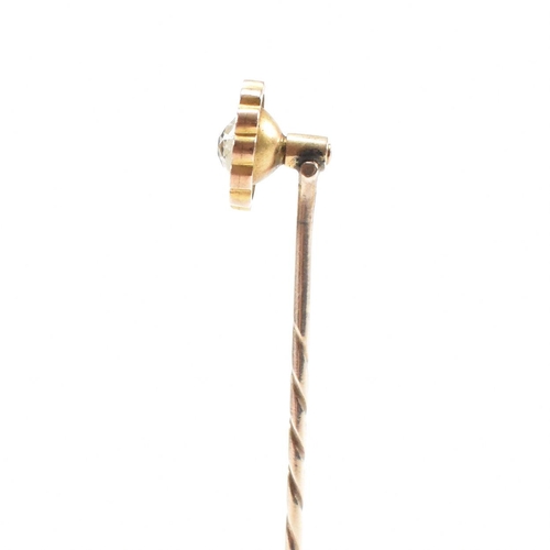 An antique yellow metal and white stone stick pin. The pin having a ...