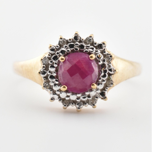 A 9ct gold ruby and diamond cluster ring. The ring with a central mixed ...